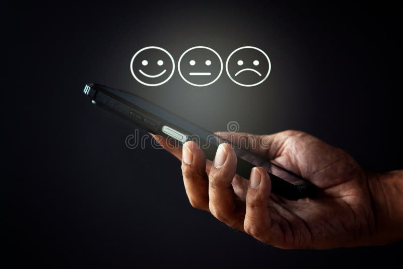A Hand Holding Smartphone with Three Emoticon Faces. Stock Photo ...