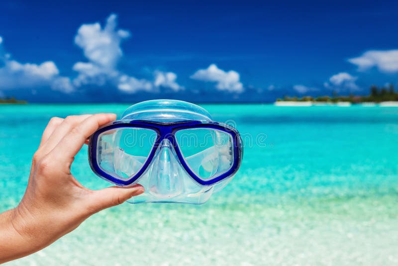 Hand Holding Snorkel Googles Against Blurred Beach and Sky Stock Photo ...