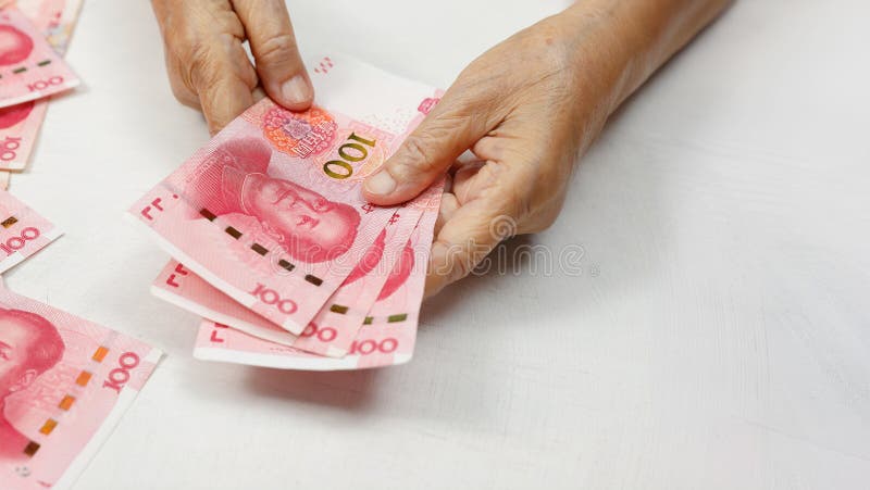 Hand Holding Stack of 100 Yuan Notes on Table. Stock Photo - Image of ...