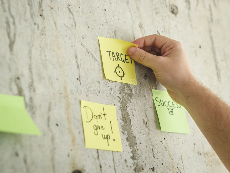 Hand Holding Sticky Note with Message Target on Wall. Stock Photo ...