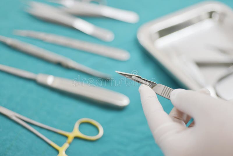 Hand Holding Surgical Instruments Stock Image - Image of clinic, green ...