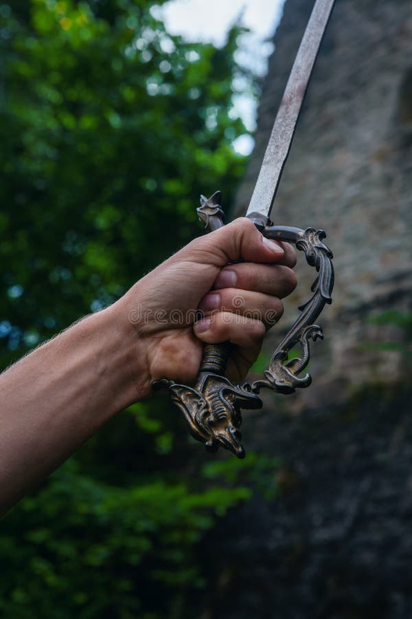 Hand Holding a Sword in Front of Old Castle Stock Image - Image of ...