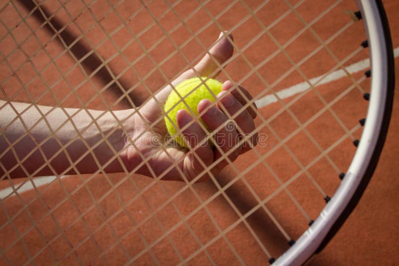Hand Holding Tennis Ball through Racket String Stock Image - Image of ...