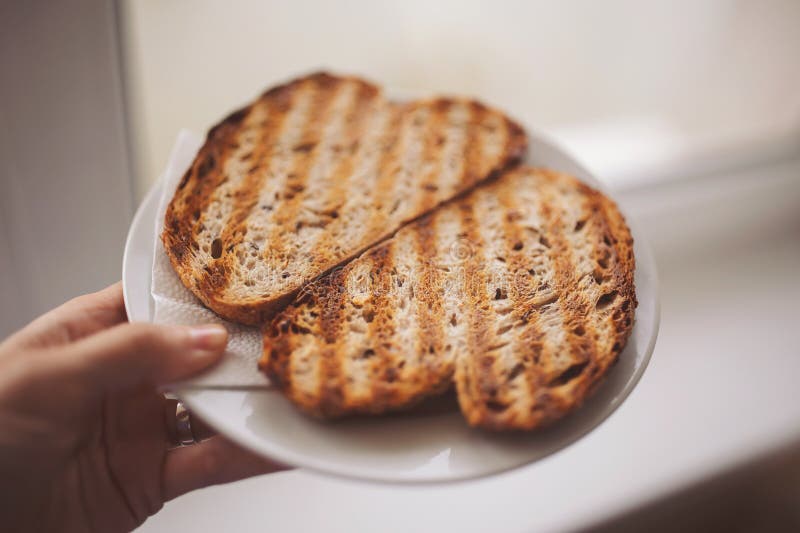 Hand Holding Toast Integral Bread on White Plate. Fresh Breakfast Stock ...