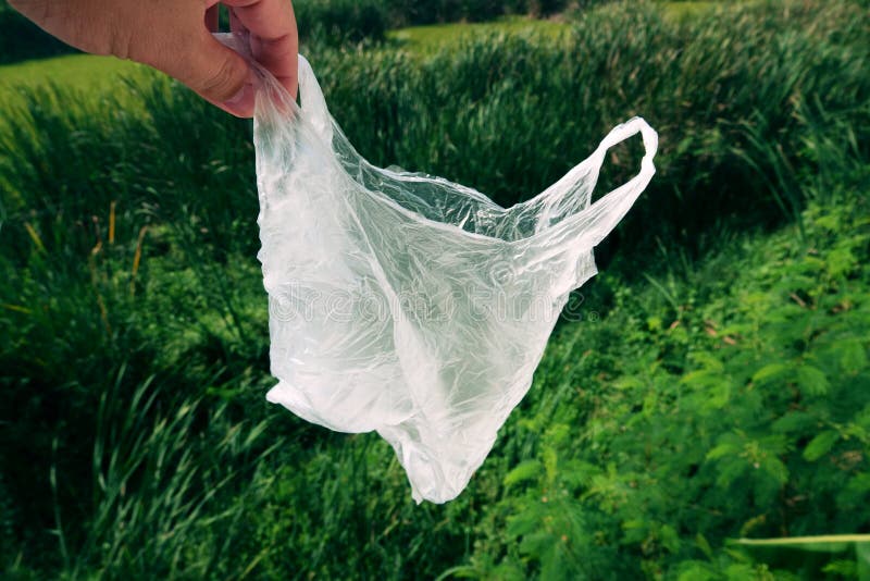 Hand Holding Transparent Empty Plastic Bag on Blurred Green Garden ...