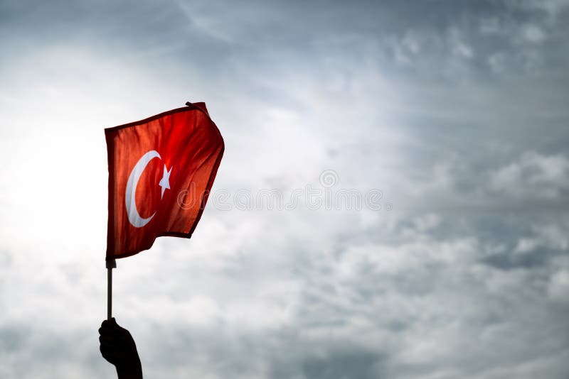 Hand Holding Turkish Flags on a Blue and Cloudy Sky and on the Day of ...
