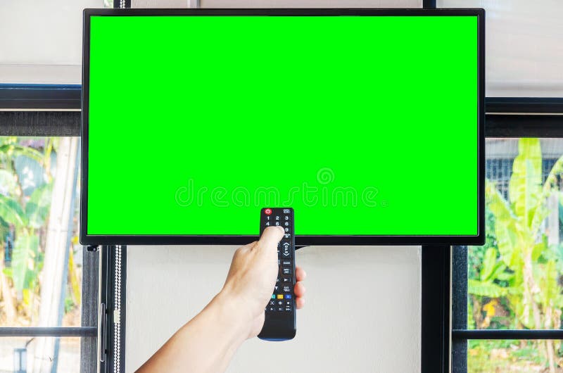 Hand Holding TV Remote Controller Over Green Screen a Modern Television ...