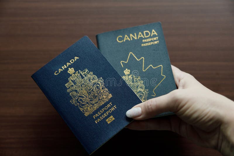 Hand Holding Two Canadian Passports Side by Side Showcasing the ...