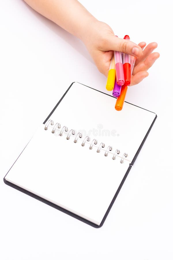 Hand Holding Various Coloured Markers with a Notebook Stock Photo ...