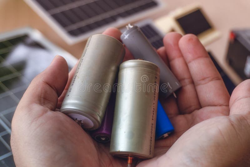 Hand Holding Various Rechargeable Batteries with Solar Energy Setup in ...