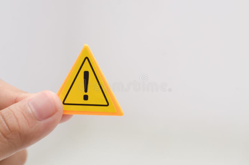 A Hand Holding a Yellow Warning Sign Emphasizes the Importance of ...