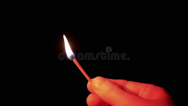 Hand Holds a Burning Match in Red Lighting on a Black Background in ...