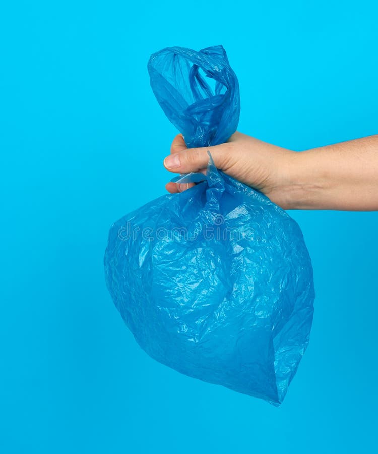 Hand Holds an Empty Blue Plastic Bag on a Blue Background Stock Image ...