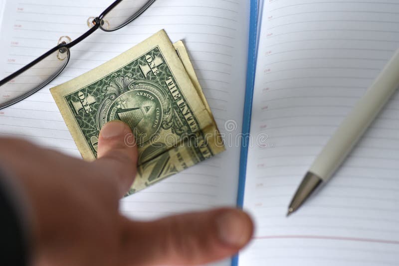 The Hand Holds the Money in the Notebook on the Desk in the Office. a ...