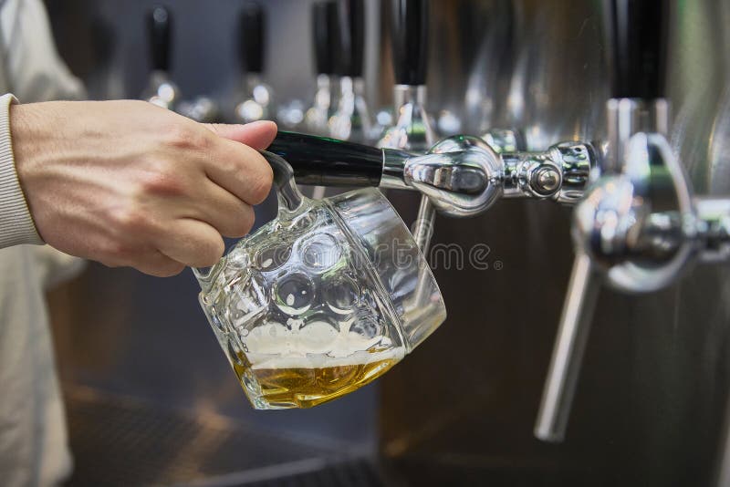 A Hand Holds a Mug of Beer in a Self-service Beer Bar Stock Image ...
