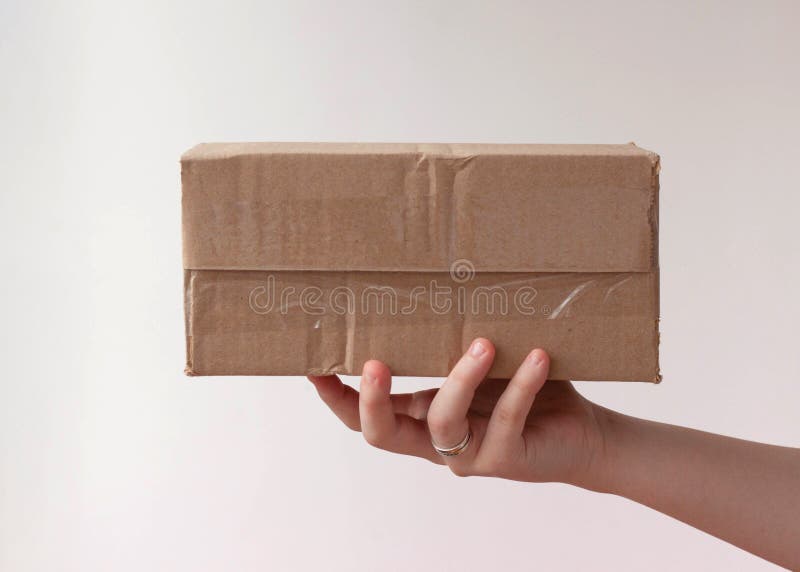 A Hand Holds Out a Package, a Crumpled Cardboard Box Stock Image ...