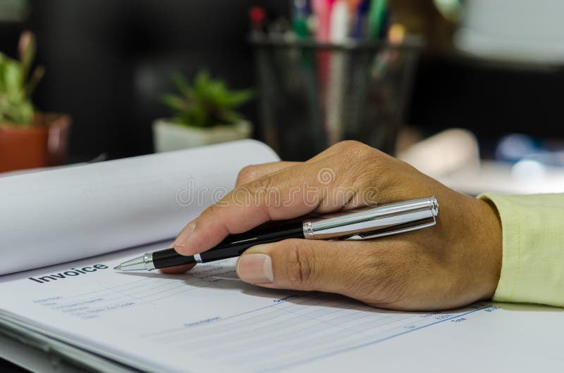 Hand Holds Pen and Paper Work Invoice on the Desk Stock Image - Image ...