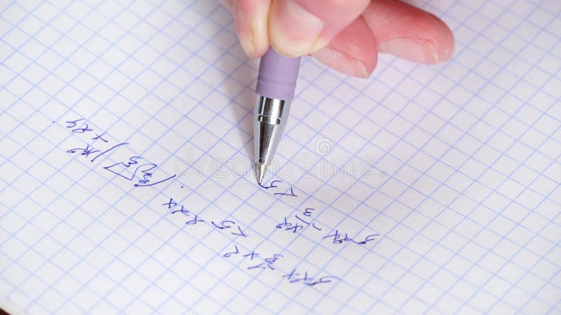 The Hand Holds a Pen and Writes a Mathematical Formula in a Notebook ...