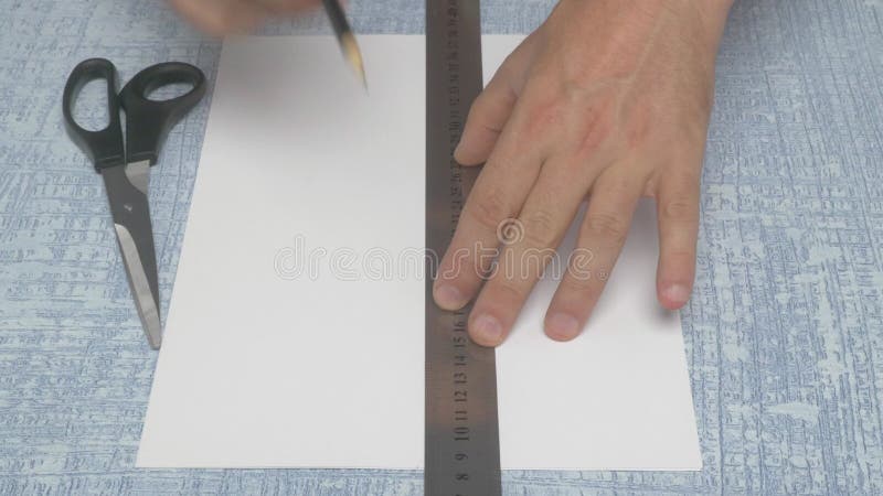 Preparing To Cut Paper Using a Ruler and a Pair of Scissors for a ...