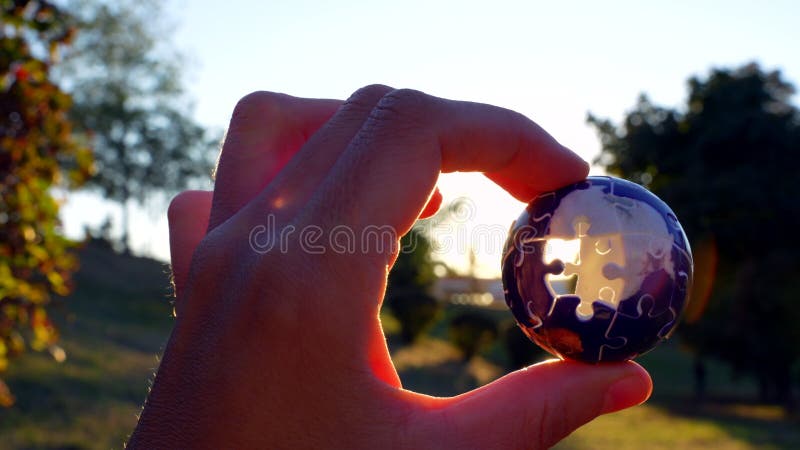 Close-Up of Hand Catching Sun Rays in 3D Globe Puzzle Pieces Stock ...