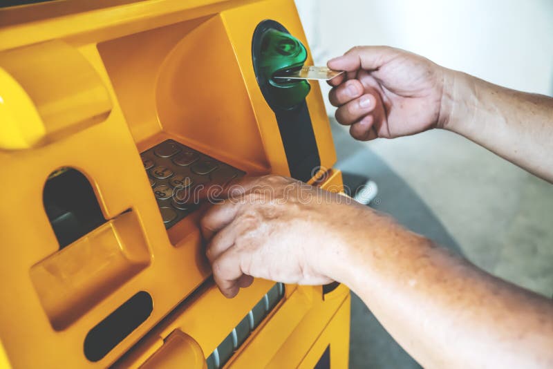 Hand Inserting ATM Card into Bank Machine and Hand Entering PIN/pass ...