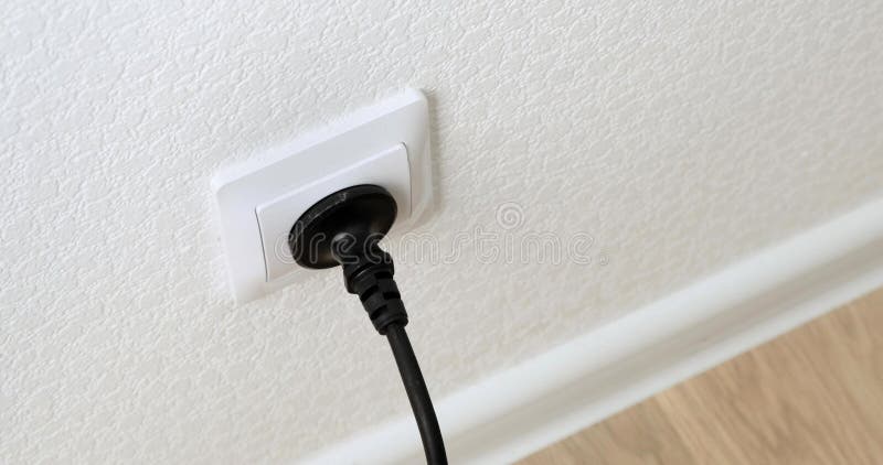 Hand Inserting Black Power Plug into an White Electricity Socket. Close ...