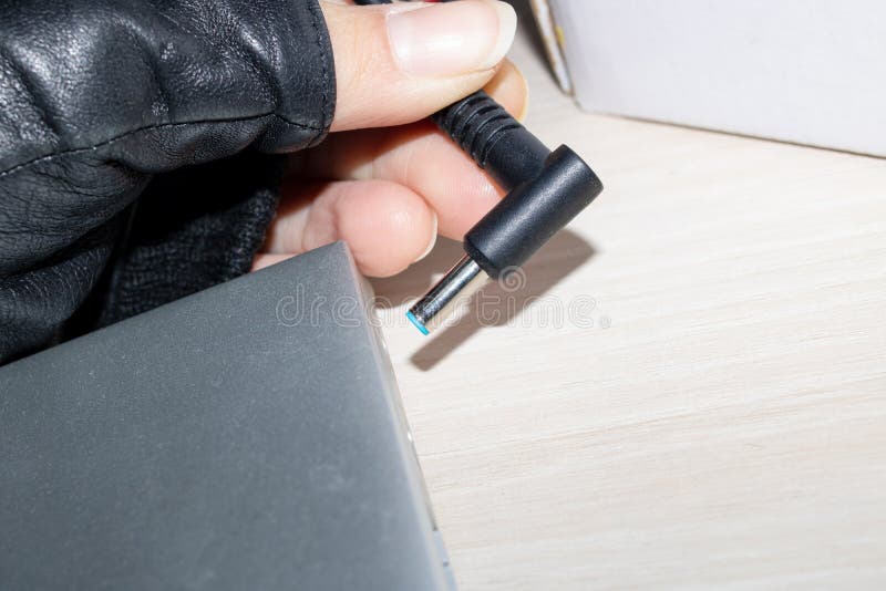 Hand Inserting Charger into Laptop on Wooden Table Stock Photo - Image ...