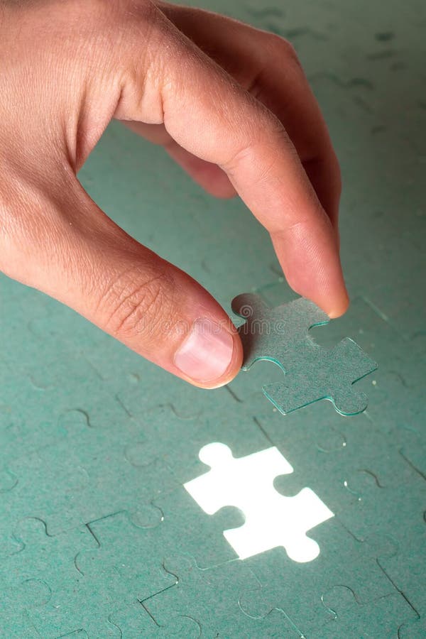 Hand Inserting Missing Piece of Jigsaw Puzzle Stock Photo - Image of ...