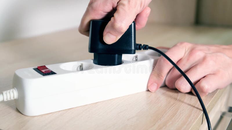 A Hand Inserting a Plug into Electrical Power Strip Close Up, Charging ...