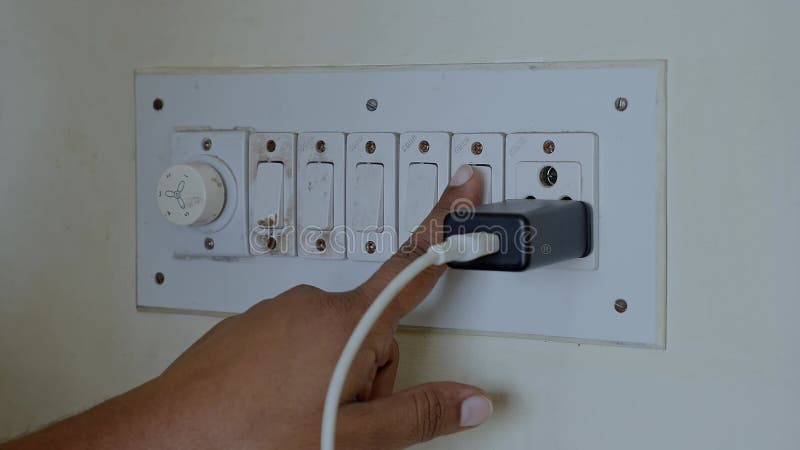 Hand Inserting Power Adaptor into Electrical Socket in Close-up Stock ...