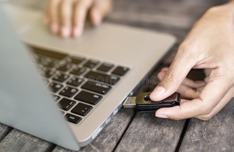 Hand Inserting USB Flash Drive into Computer Laptop on the Desk. Stock ...