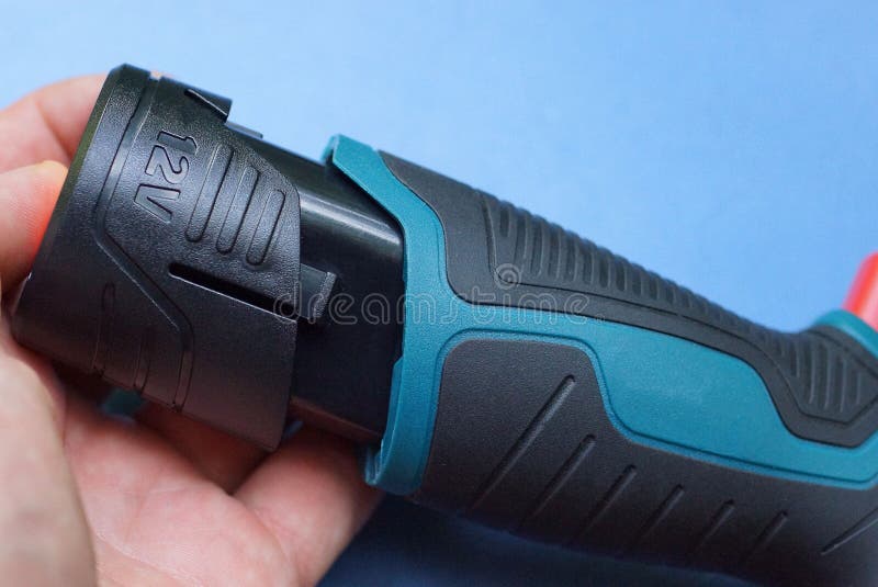 Hand Inserts a Black Plastic Battery into the Handle of a Screwdriver ...