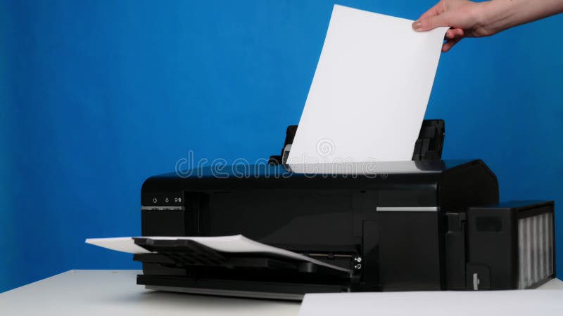 A Hand Inserts Blank Sheets of A4 Paper into the Printer on a Blue ...