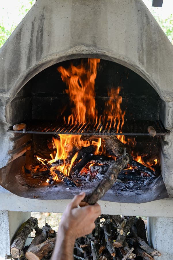 Hand Keeps Fire Going in a Grill with Fiery Flames Stock Photo - Image ...