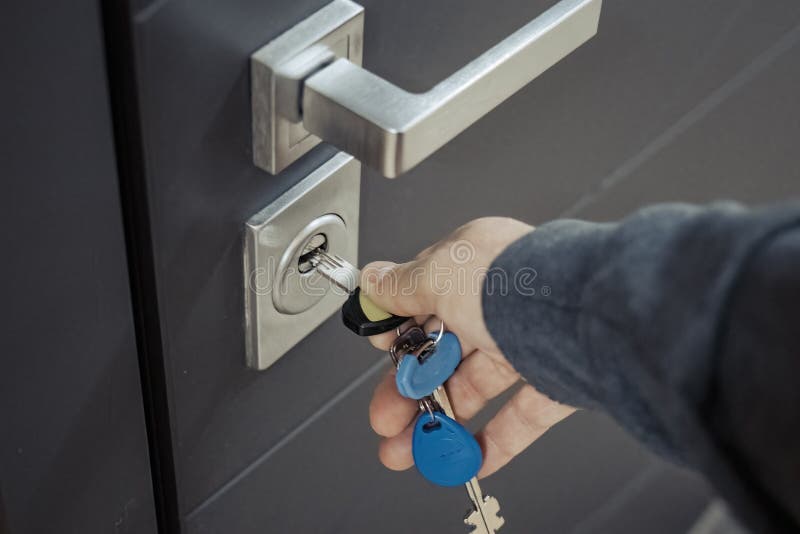 Hand with Key Opening or Closing Gray Entrance Door Stock Photo - Image ...