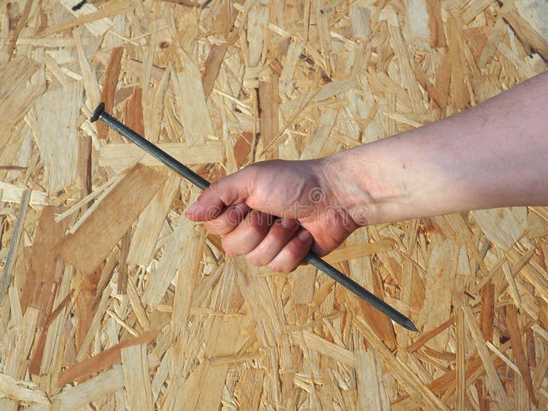 Hand with a Large Nail. Construction and Repair of Buildings Stock ...