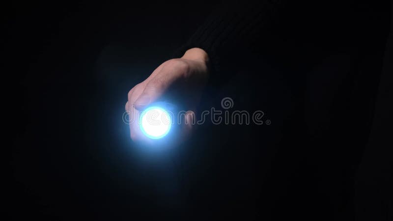 Hand with a Led Flashlight Shining in the Darkness with Blue Beam into ...