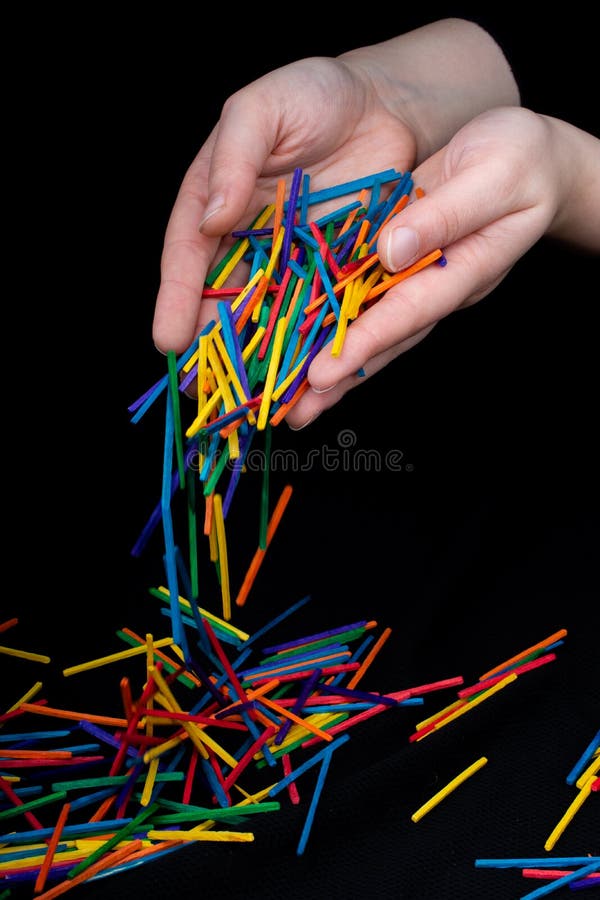 Hand Letting Coloured Wooden Sticks Drop on Black Stock Image - Image ...