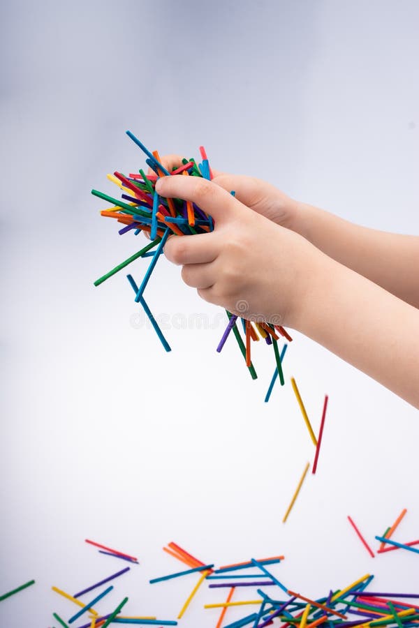 Hand Letting Coloured Wooden Sticks Drop on White Stock Photo - Image ...