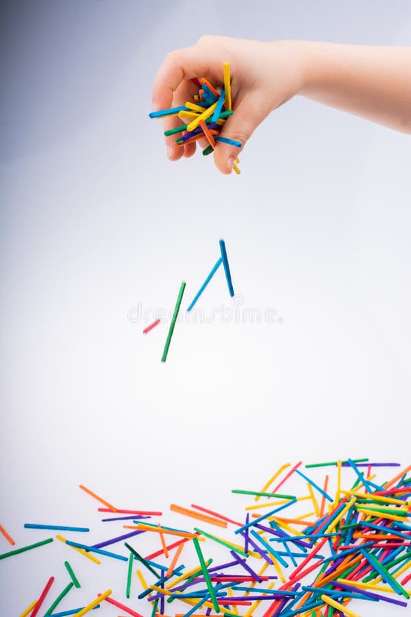 Hand Letting Coloured Wooden Sticks Drop on White Stock Photo - Image ...