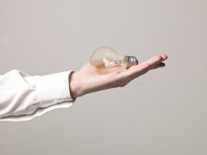 Hand with light bulb stock photo. Image of studio, grey - 9069766