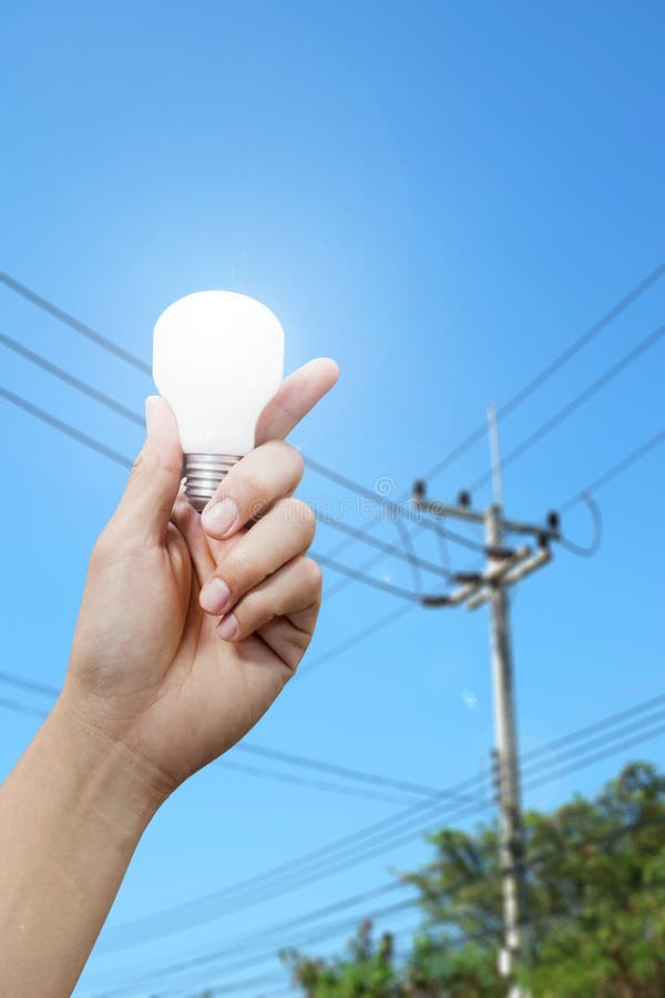 Hand with Light Bulb, Electricity Pole Background Stock Photo - Image ...
