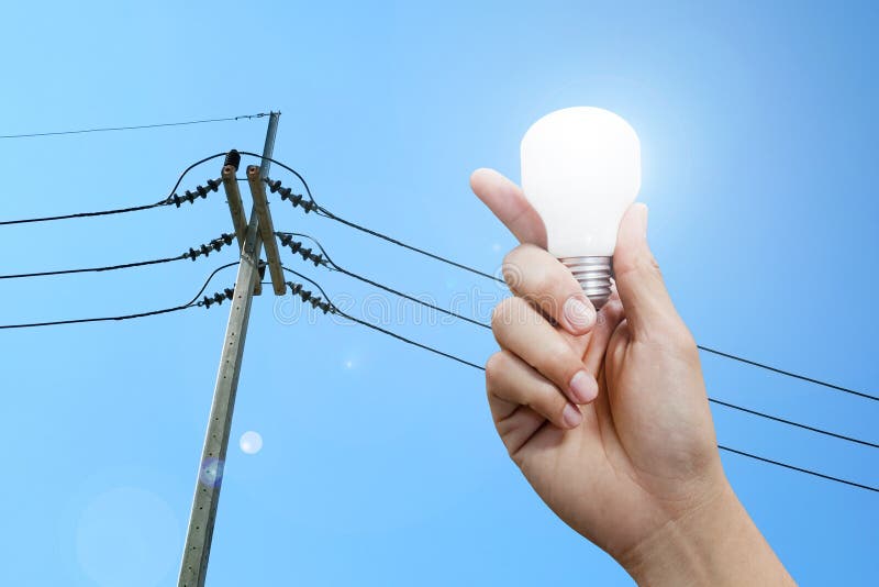 Hand with Light Bulb, Electricity Pole Background Stock Photo - Image ...