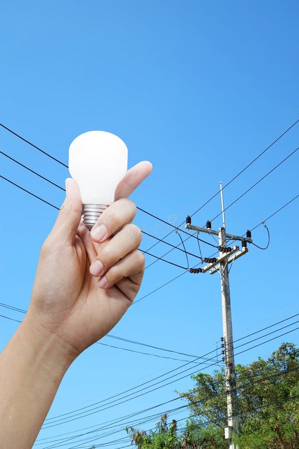 Hand with Light Bulb, Electricity Pole Background Stock Photo - Image ...