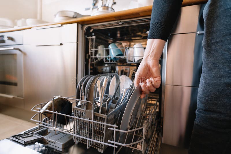 Person loading dishwasher stock image. Image of plate - 247474479