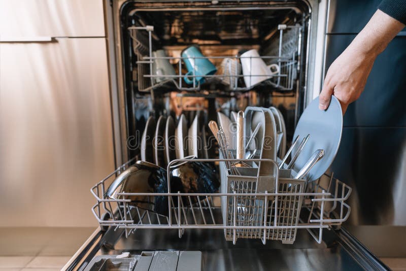 Person loading dishwasher stock photo. Image of machine - 247474482
