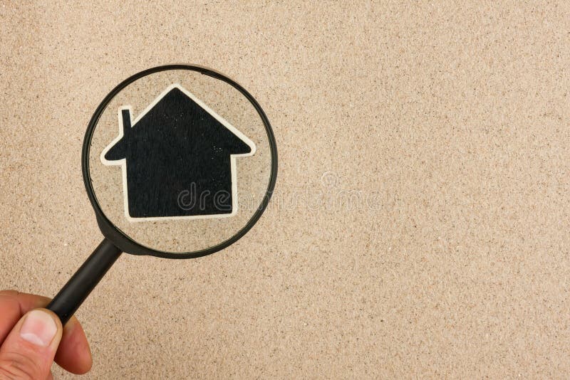 Hand with Magnifying Glass Over the House in the Sand Stock Image ...