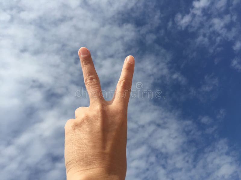 Hand Making Victory Sign Against Blue Sky Stock Photo - Image of sign ...