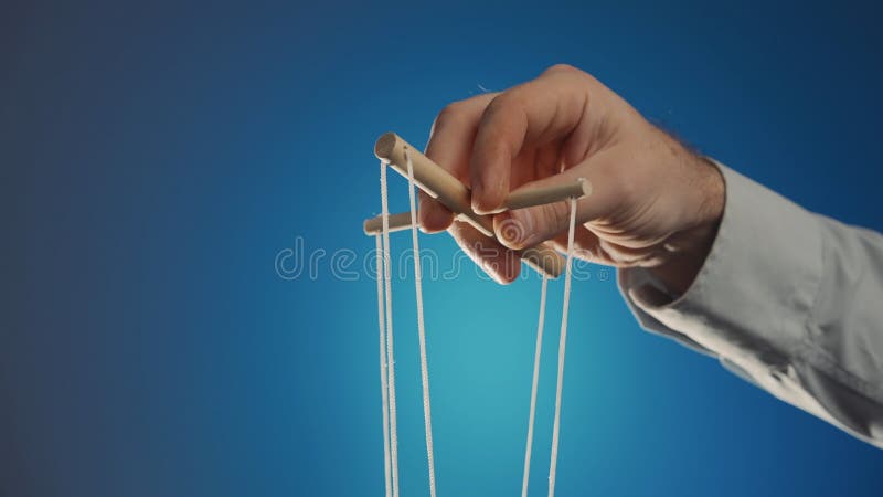 The Hand of a Man in a Gray Shirt Controls a Puppet Using a Wooden ...