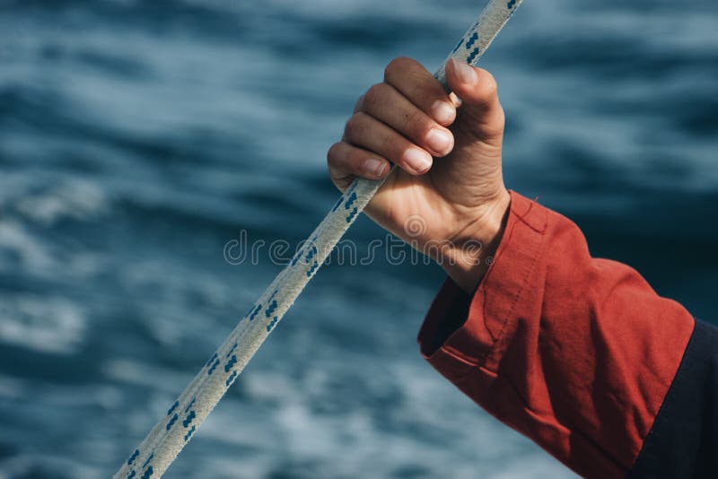 Hand of a Man Holding on the Rope with the Waves of the Sea in the ...